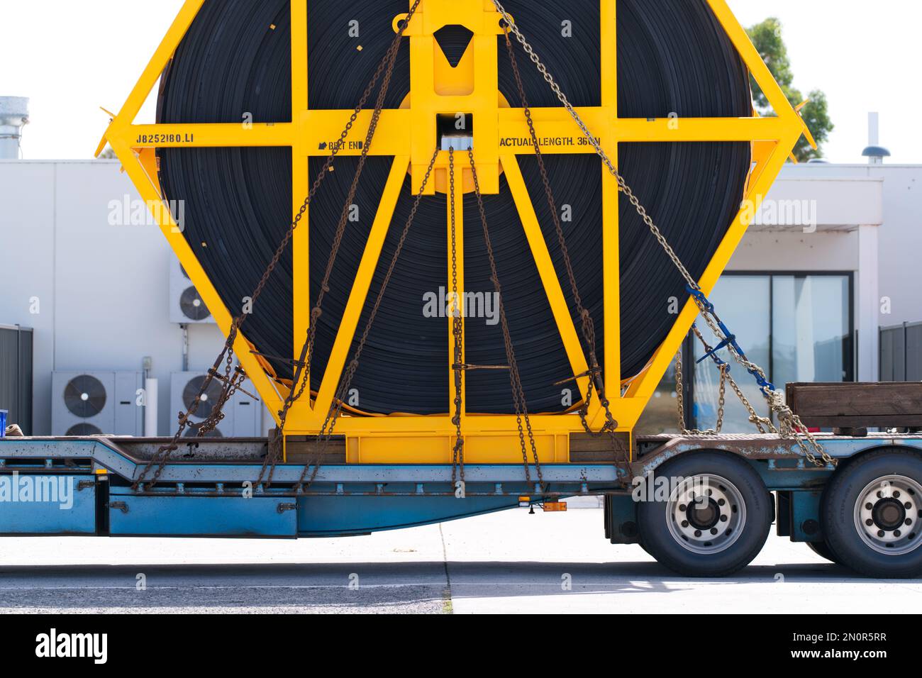 Truck carrying steel shipment in a yellow container with light sky ...