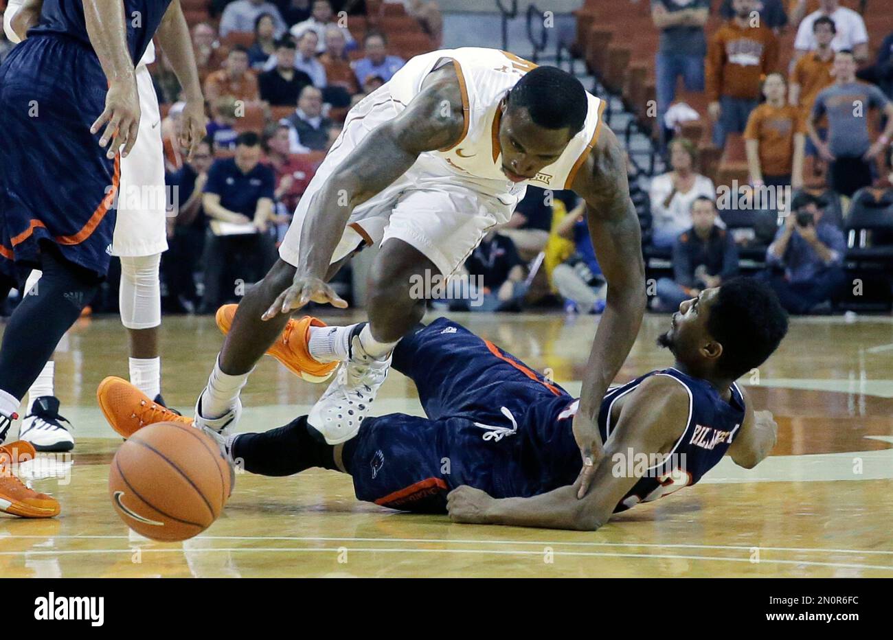 Texas guard Kendal Yancy, left, drives over UTSA guard Nick Billingsley ...