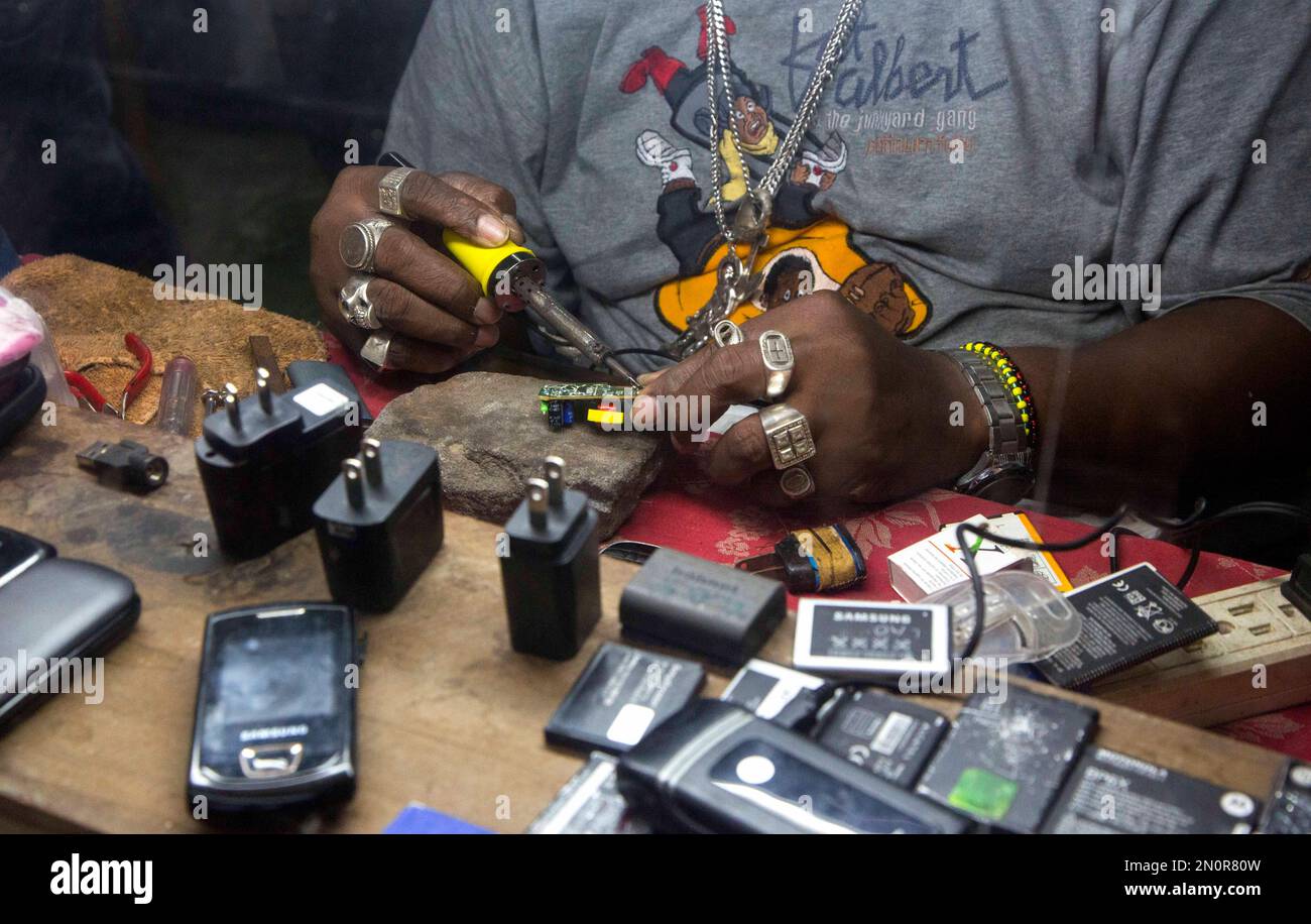 In this Dec. 4, 2015 photo, a man repairs mobile phones at his ...