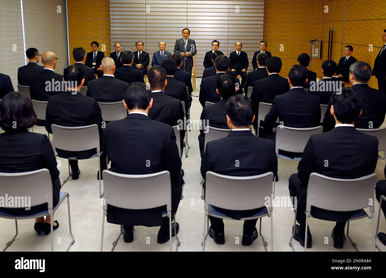 Japanese Chief Cabinet Secretary Yoshihide Suga, rear center, speaks ...