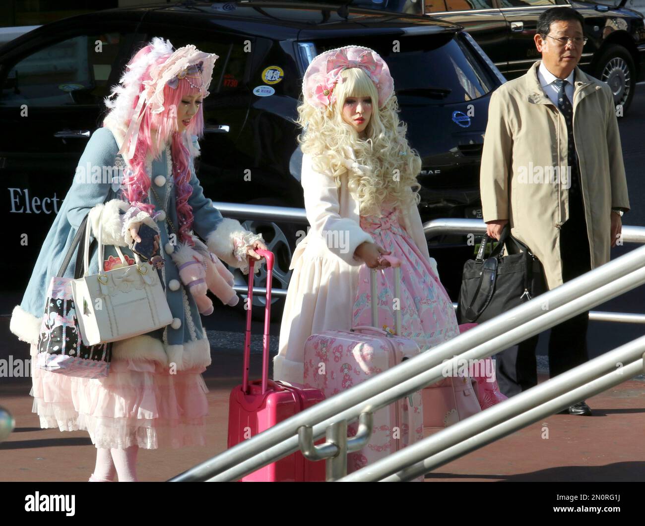 Two women clad in "Lolita" costumes walk in Tokyo, Monday, Dec. 7, 2015 ...