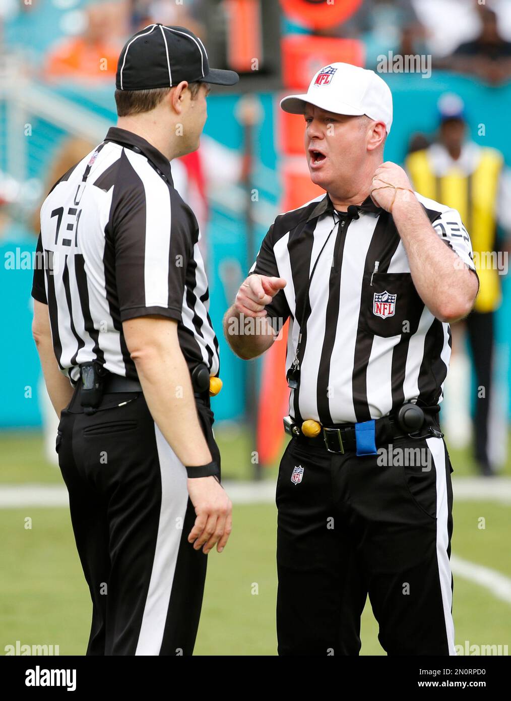 umpire Mark Pellis (131) and referee John Parry (132) talk on the field ...