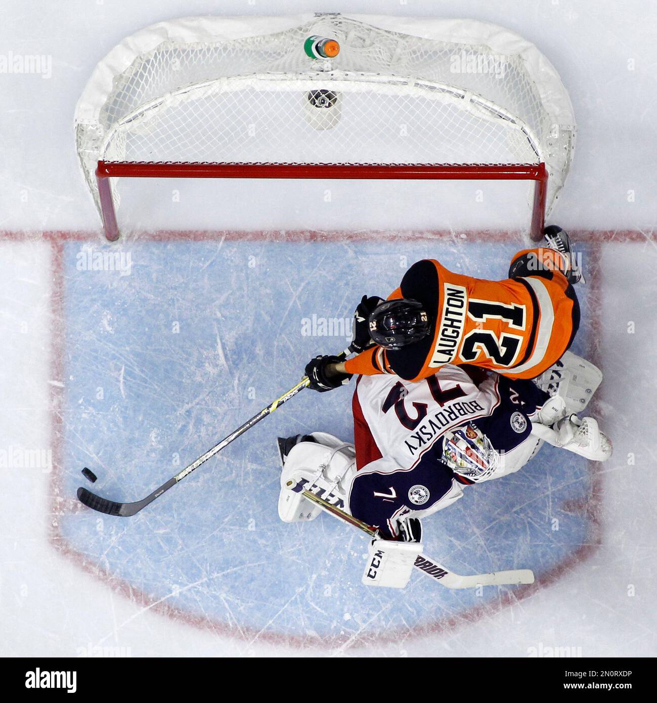 Philadelphia Flyers' Scott Laughton (21) tries to shoot a loose puck ...