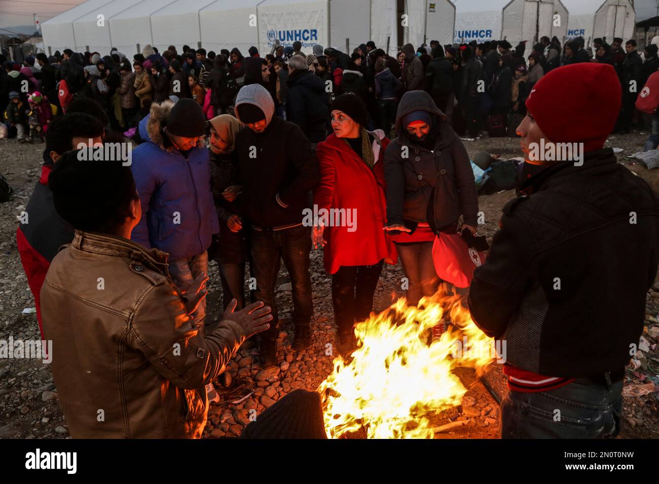 People gather around bonfires try to keep warm outside the registration ...