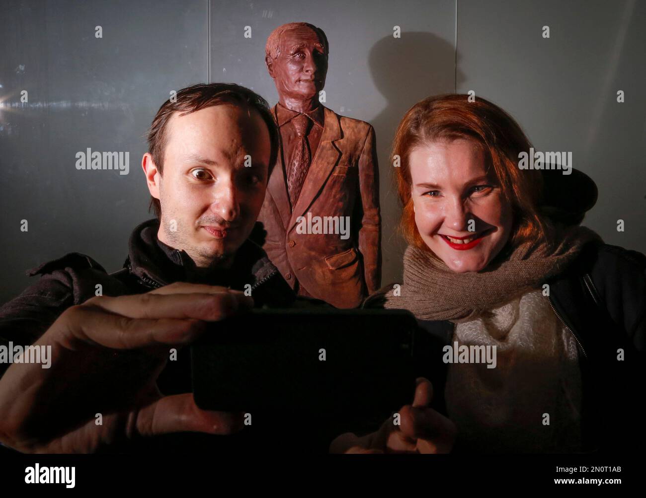 Visitors take a selfie with a chocolate statue of Russian President ...