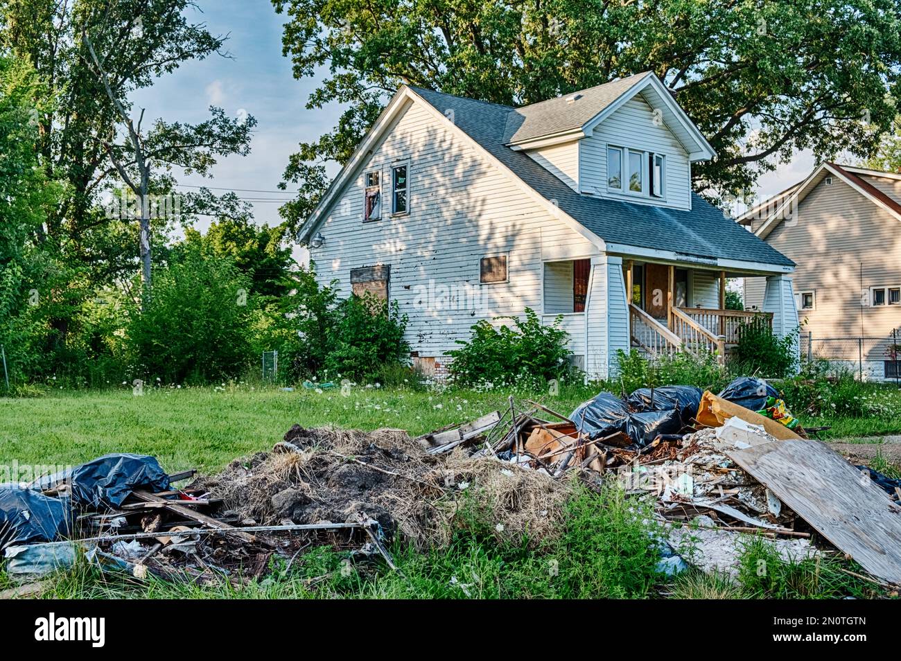 Debris from damaged homes litters the street in front of the abandoned ...