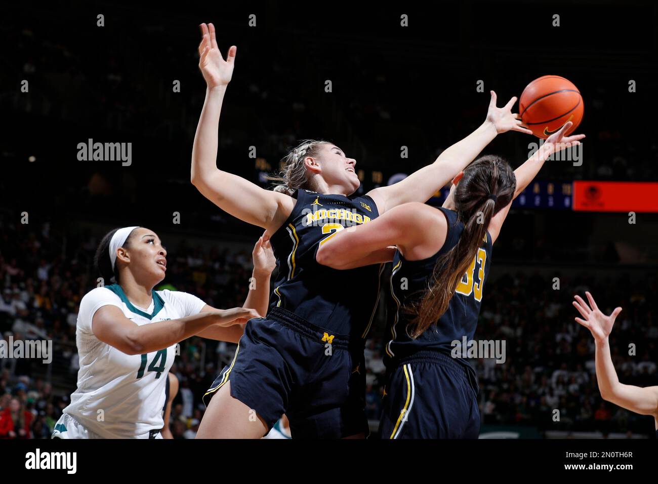 Michigan's Chyra Evans, center, and Emily Kiser, right, reach for a ...