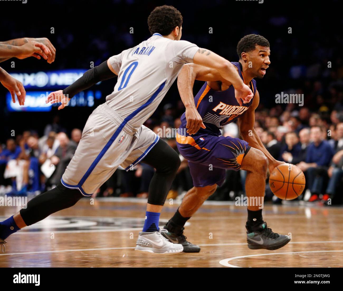 Phoenix Suns guard Ronnie Price, right, drives past Brooklyn Nets guard ...