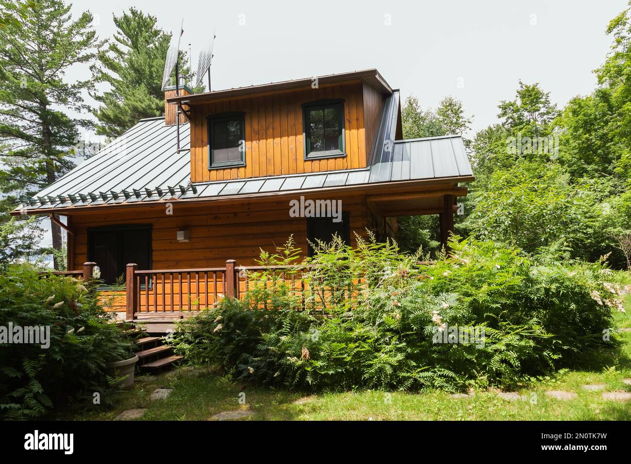 Side view of milled cottage style flat log profile home with porch and ...