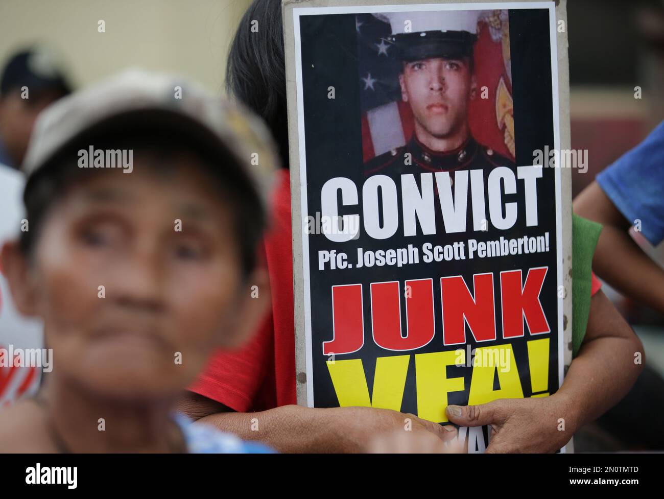A protester looks beside a slogan with a picture of U.S. Marine Lance ...