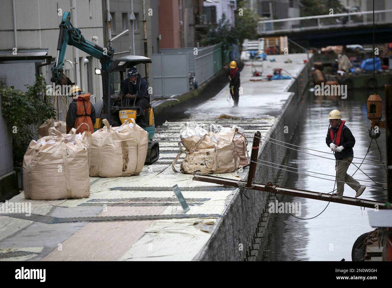 In this Nov. 26, 2015 photo, workers reinforce the dyke on Tate River ...