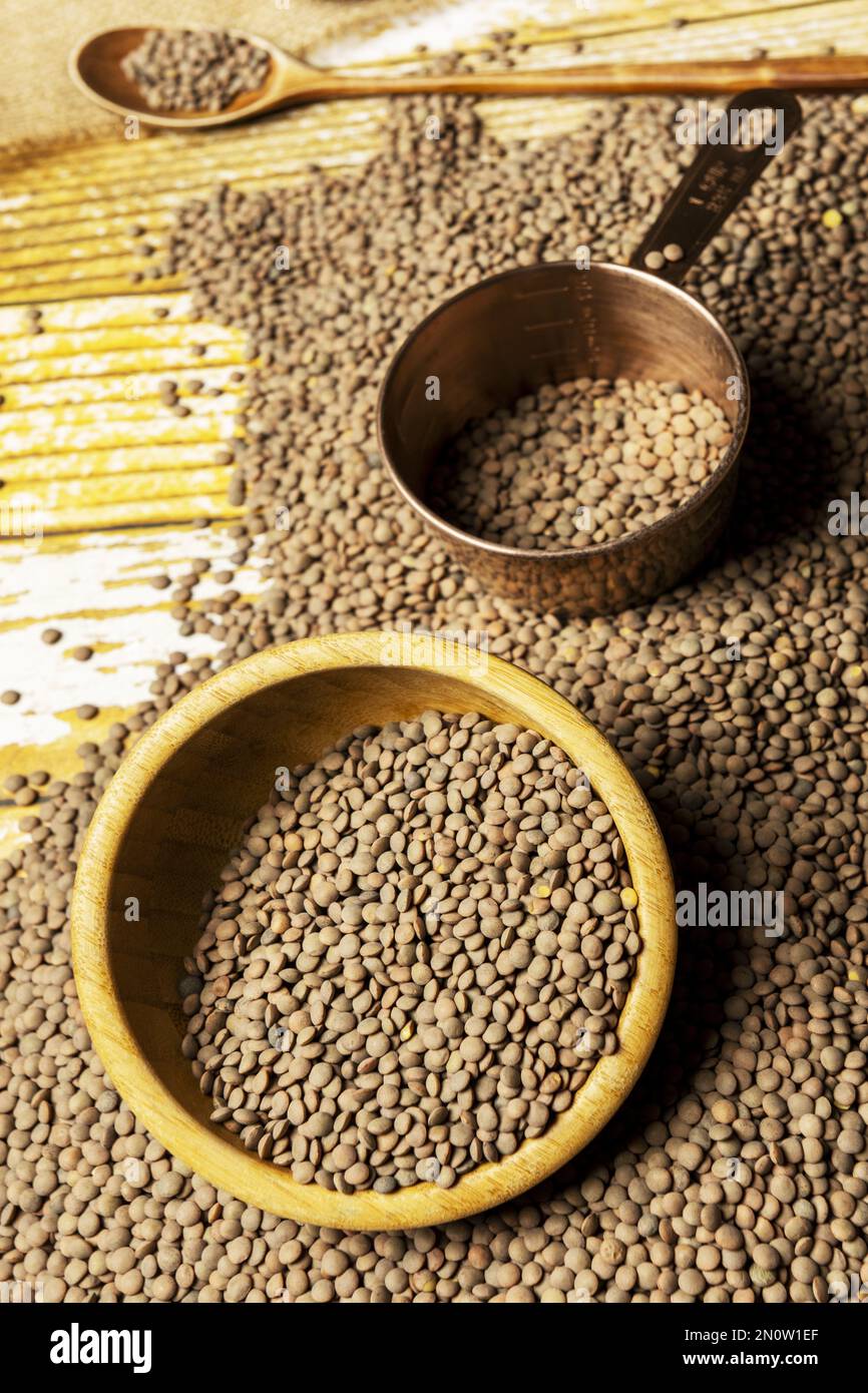 dried lentils scattered on a wooden table with bamboo wooden bowls ...