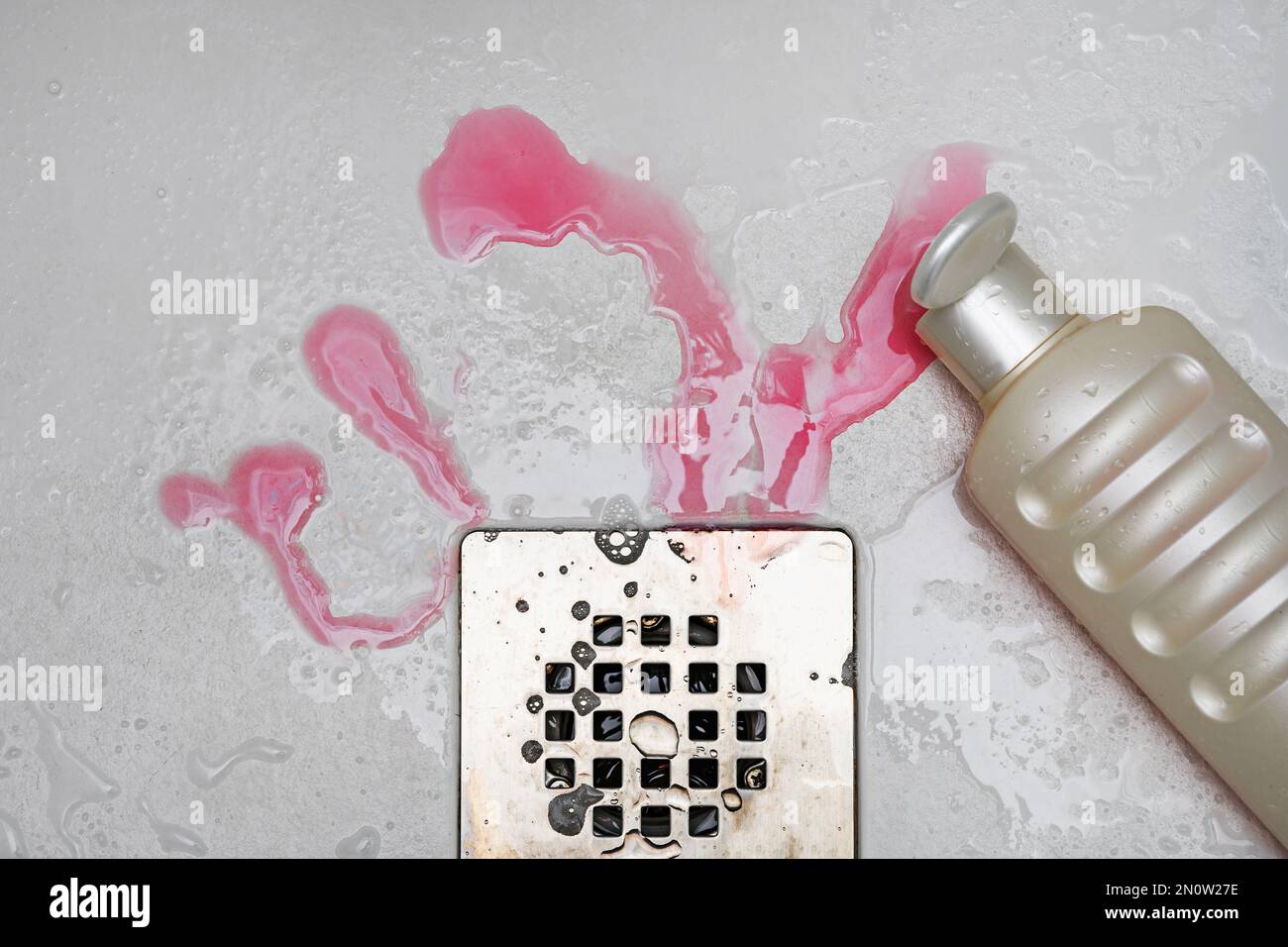 A shampoo bottle pouring its bright red contents into a metal shower ...