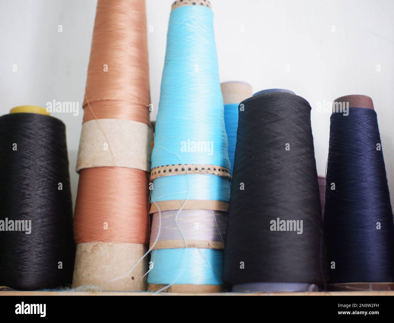 Multicolor sewing threads on wooden background.Color sewing threads on ...