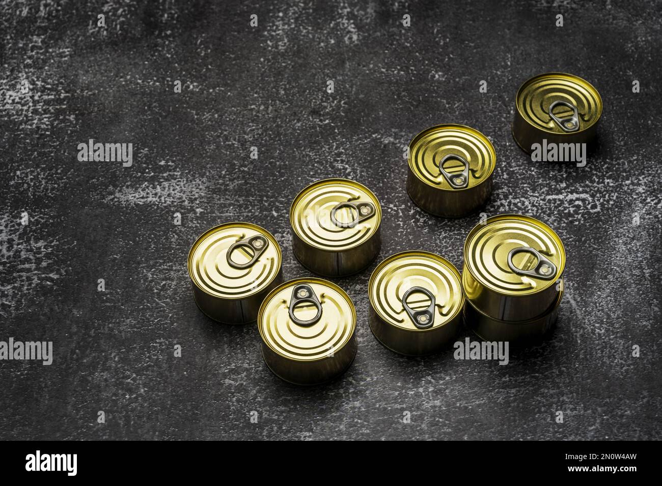 Some unopened circular canned food tins on a gray surface filled with ...