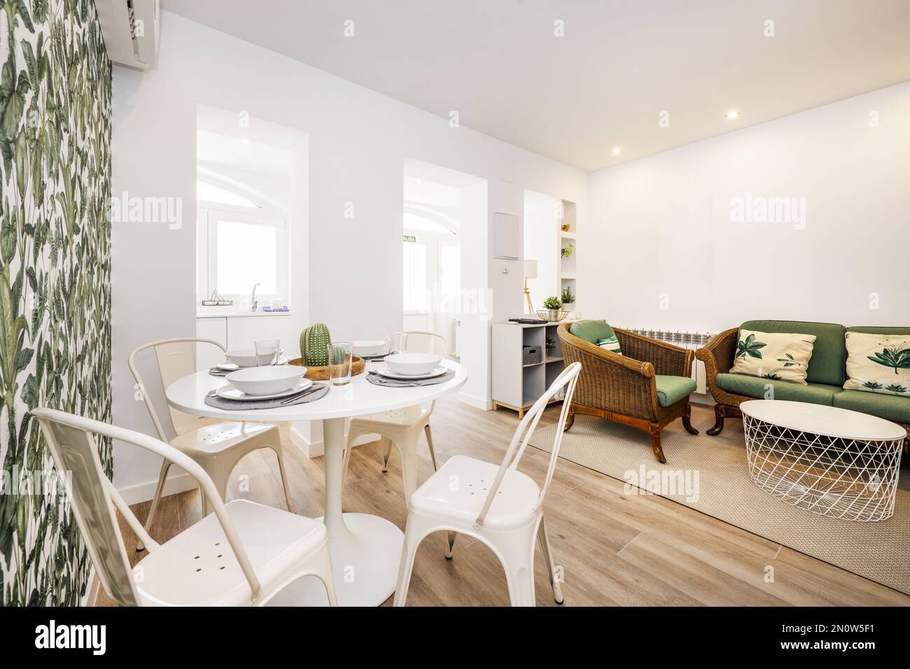 A living room furnished with a stained rattan sofa set with green ...