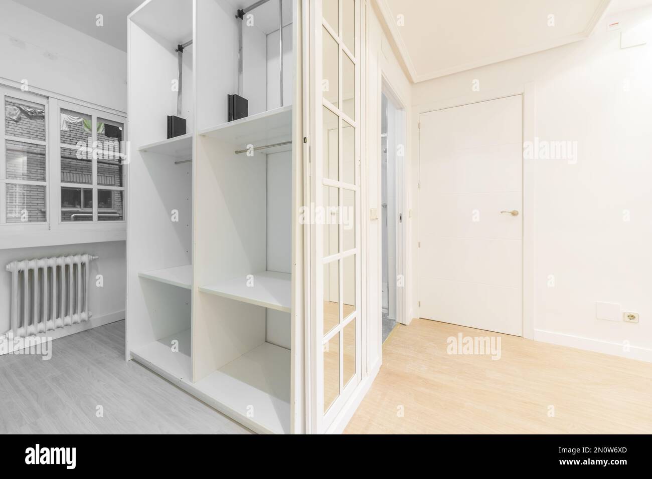 A bedroom dressing room with white and mirror aluminum sliding doors ...