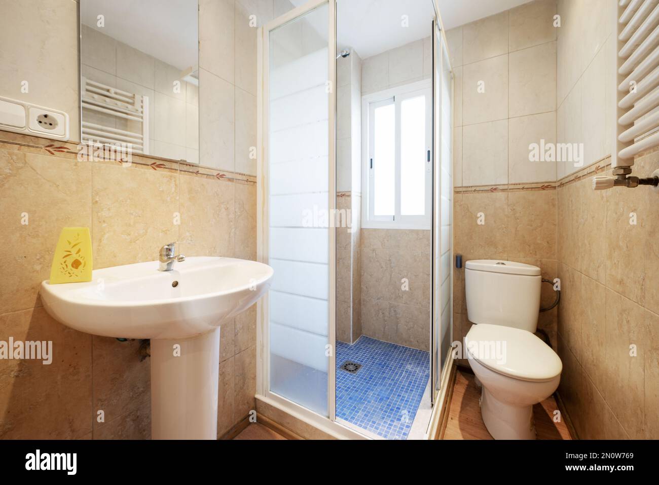 WC with white porcelain sink under a mirror embedded in the wall of a ...