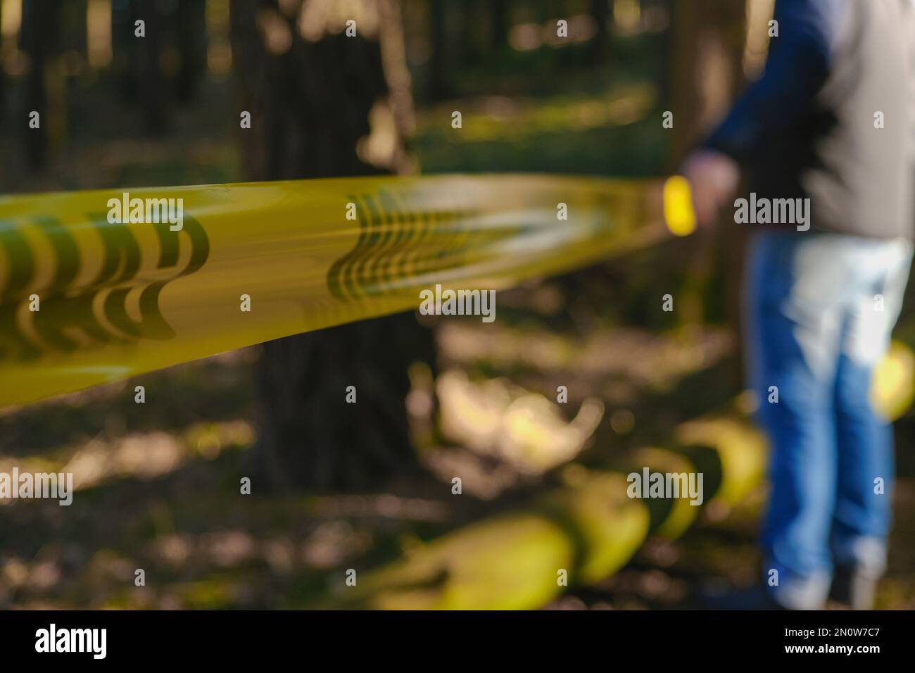 Crime scene.Entry ban. No entry. stop motion tape. Man pulling yellow ...