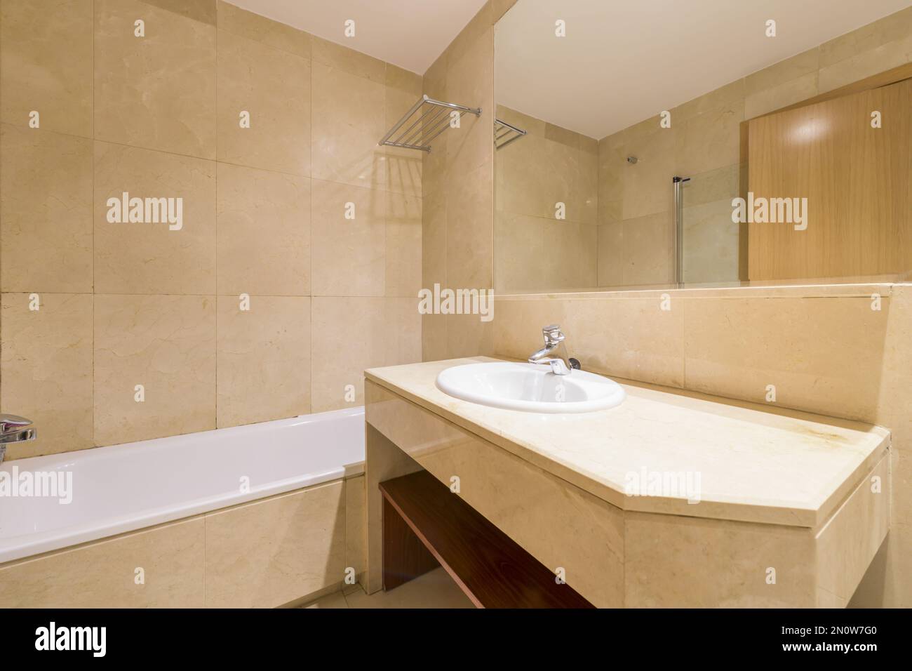 Bathroom with cream-colored marble furniture with a long bathtub and a ...