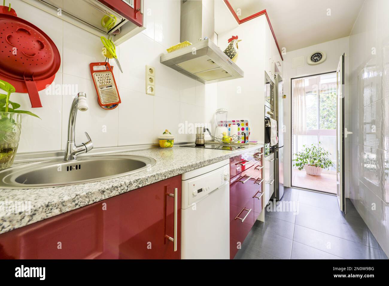Elongated kitchen with white furniture combined with blue details with ...