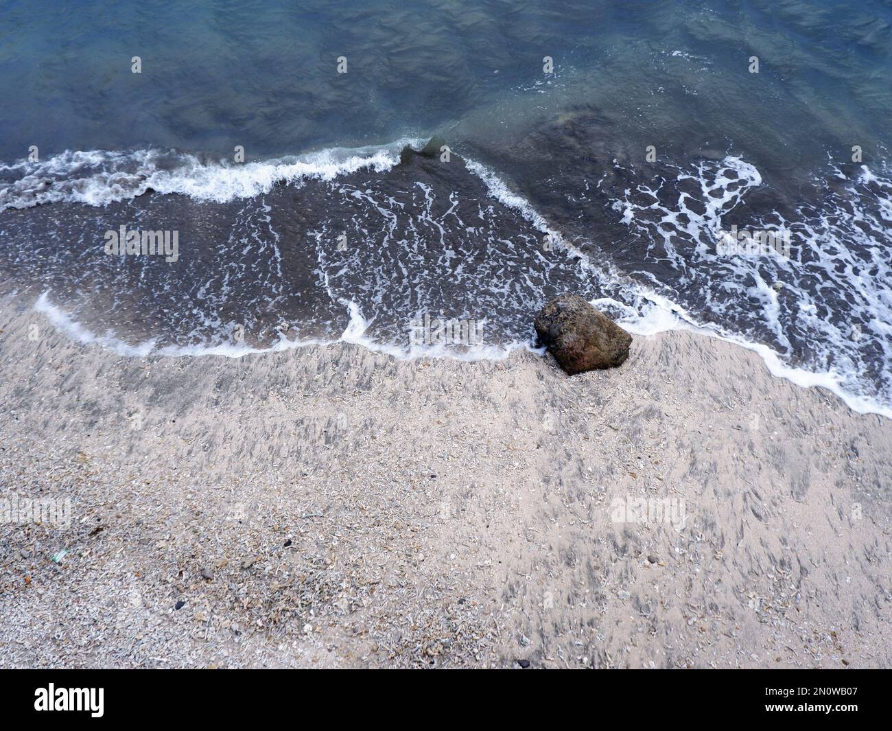 View of the shoreline from above, white waves, beach sand, clear water ...