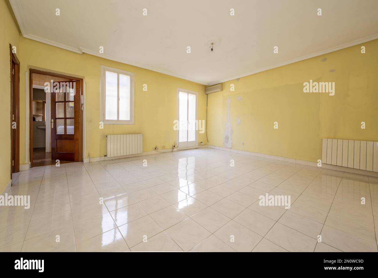 totally empty living room with light yellow painted walls, plaster ...