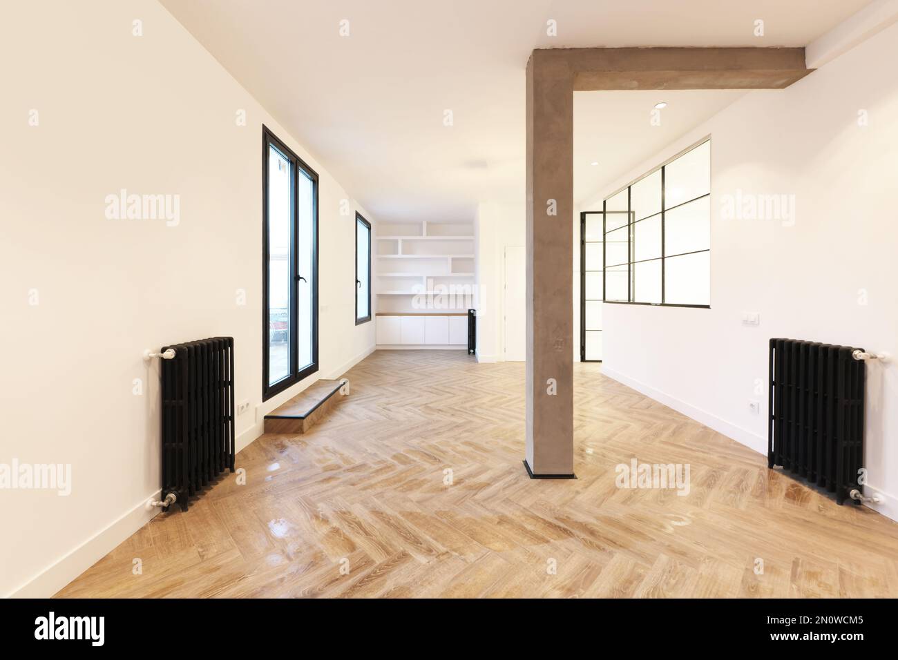 Empty room of a loft-style apartment with white painted walls, black ...