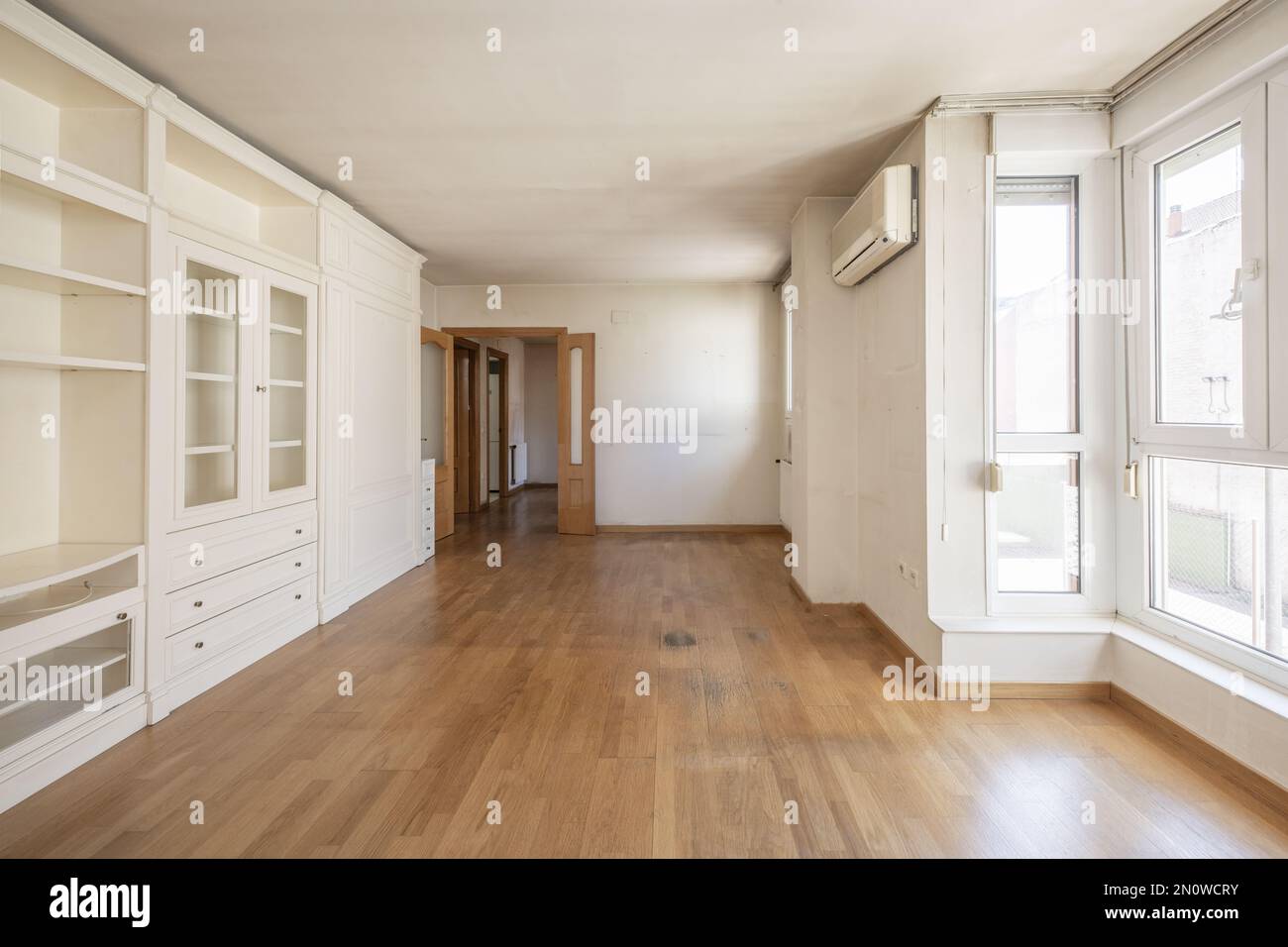 Living room of an empty house with a white lacquered wooden bookcase ...