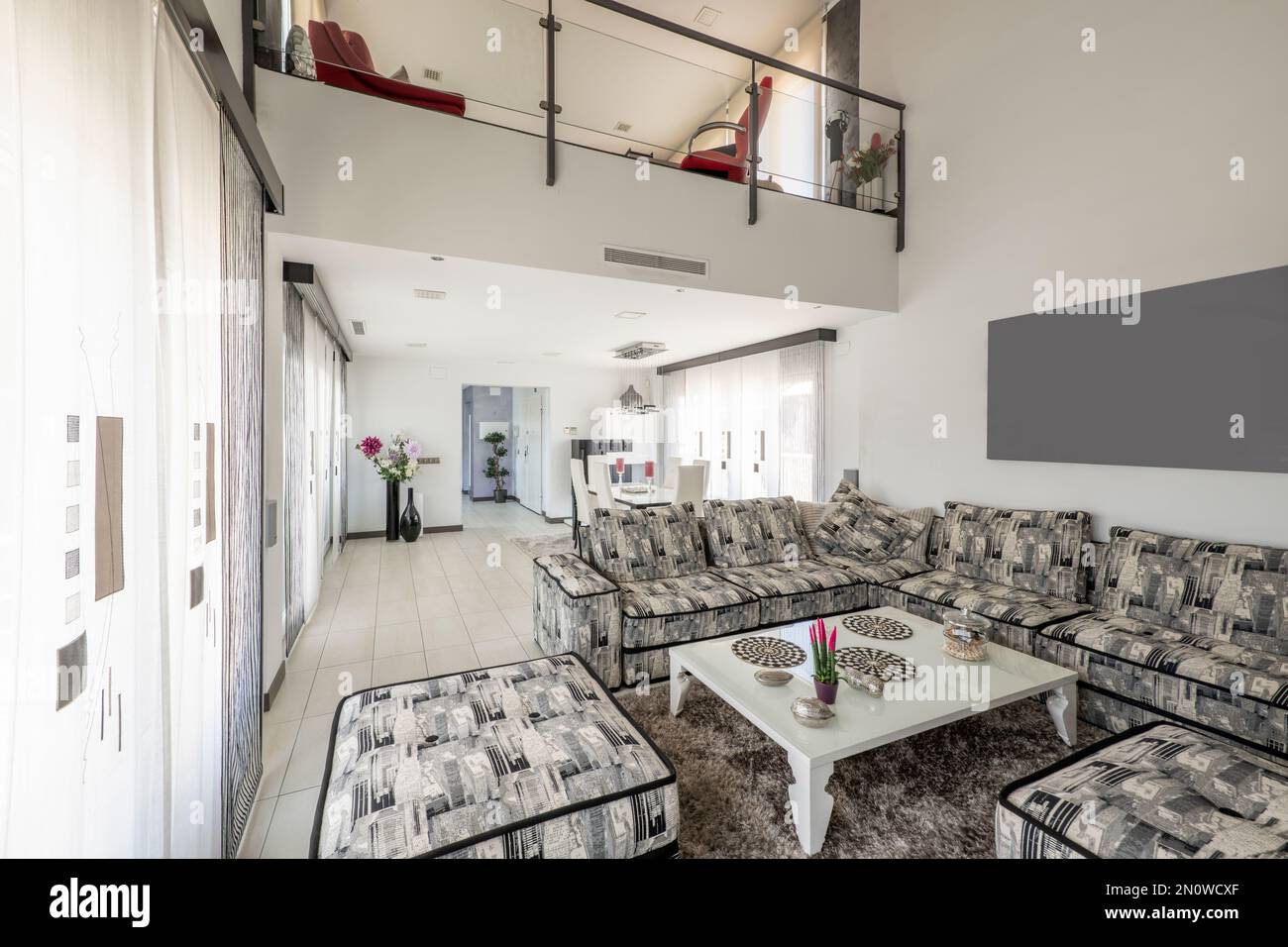 Loft-style house with sofas upholstered in gray fabric occupying an ...