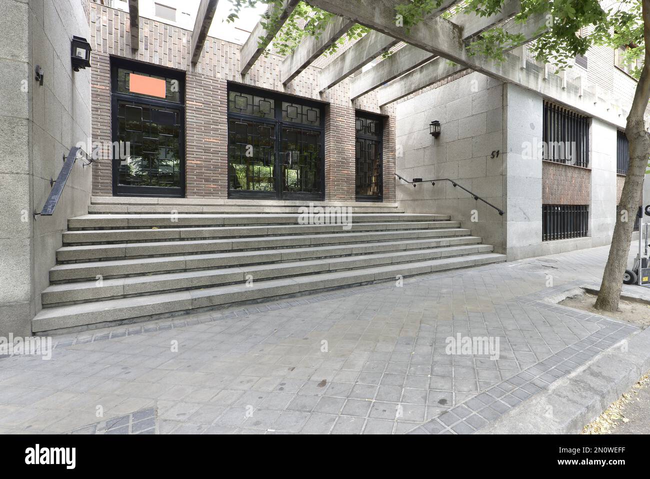 Wide access portal to a residential house with granite stairs and black ...