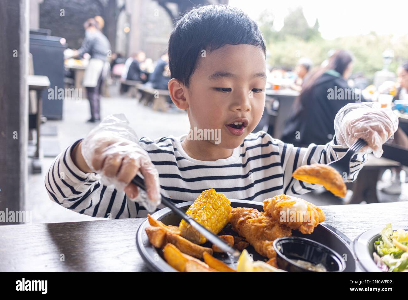 the little boy enjoys the fried food Stock Photo - Alamy