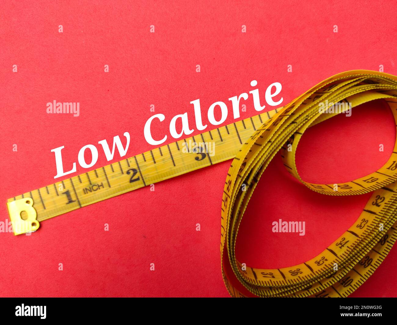 Yellow measuring tape with the word Low Calorie on a red background ...