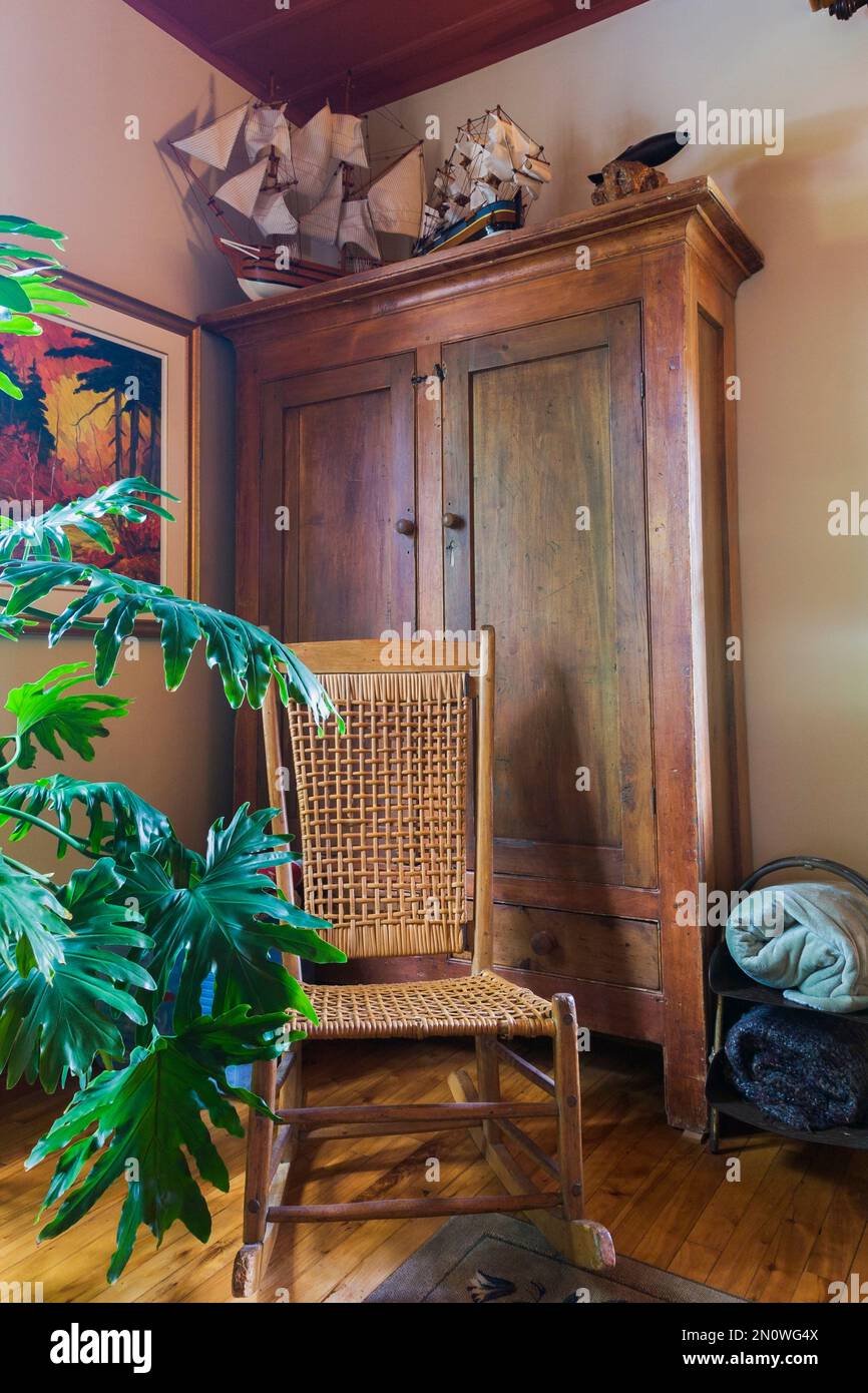 Antique woven seat rocking chair and pinewood armoire in family room ...