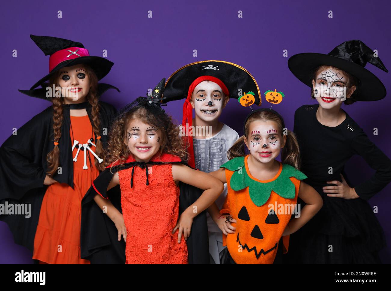 Cute little kids wearing Halloween costumes on purple background Stock ...