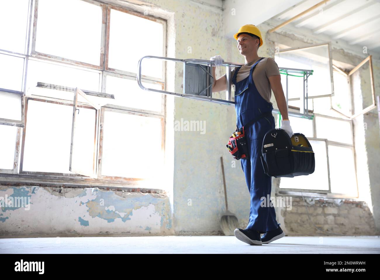 Professional constructor with ladder and toolbox in old building Stock ...