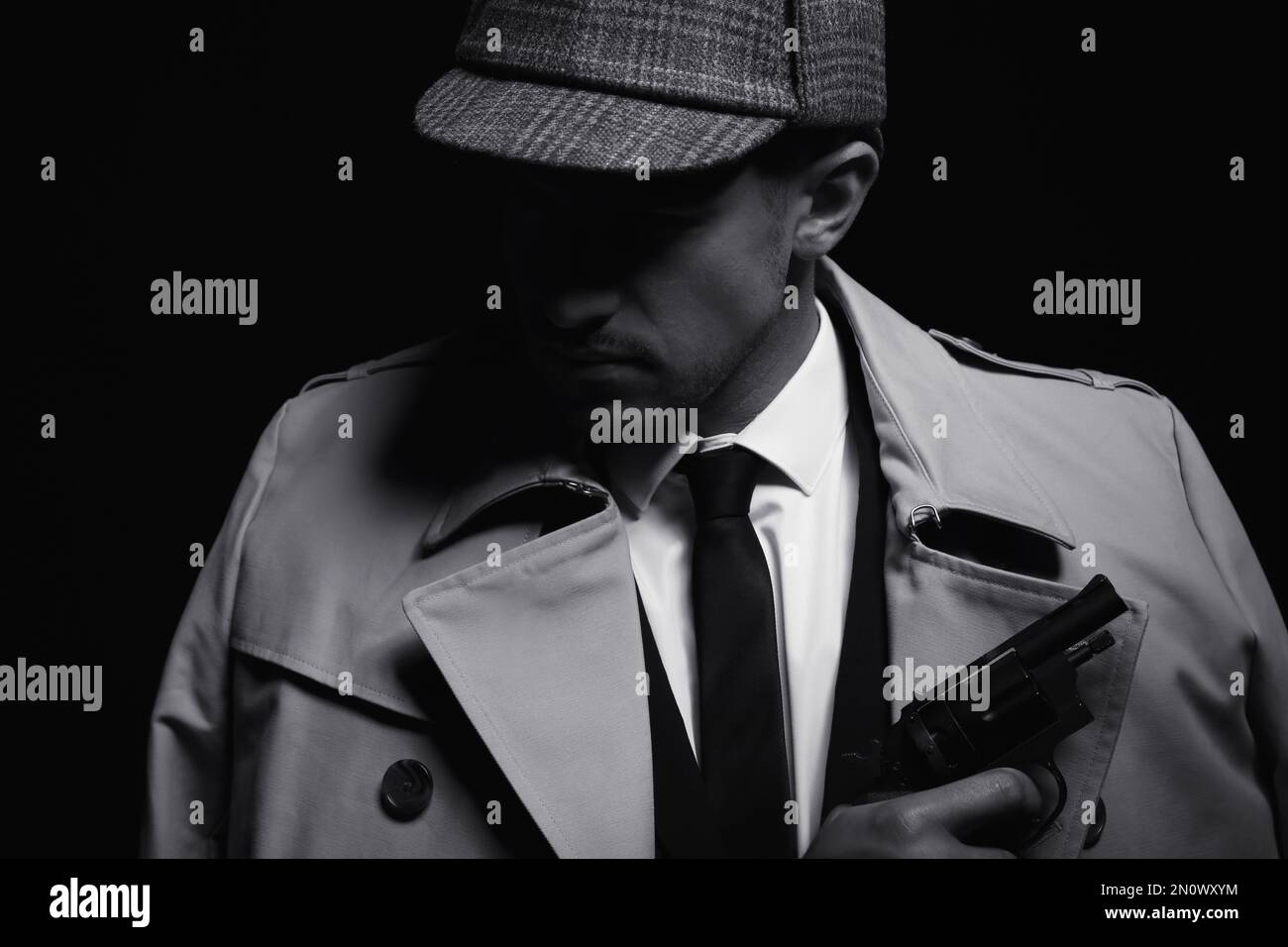 Old fashioned detective with revolver on dark background, black and ...