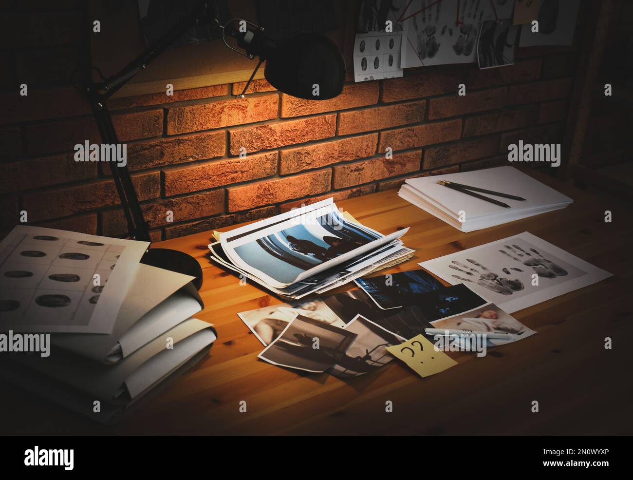 Detective workplace with documents, fingerprints and crime scene photos ...