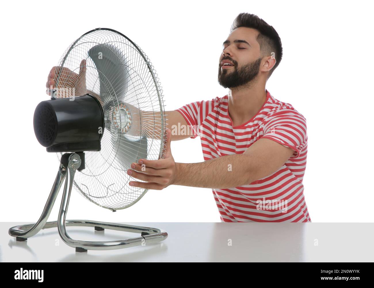Man enjoying air flow from fan on white background. Summer heat Stock ...