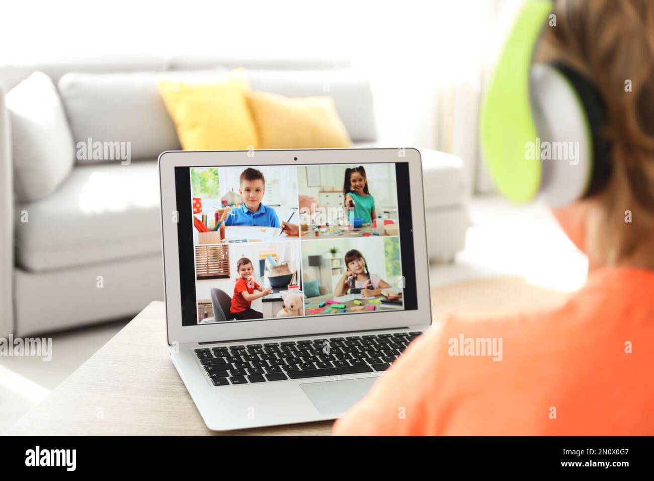 Little boy studying with classmates via video conference at home ...