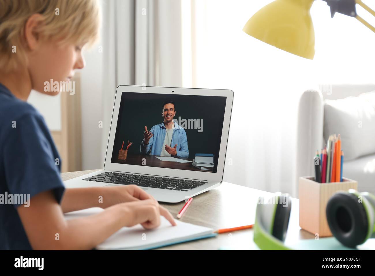 Little boy studying with teacher via video conference at home. Distance ...