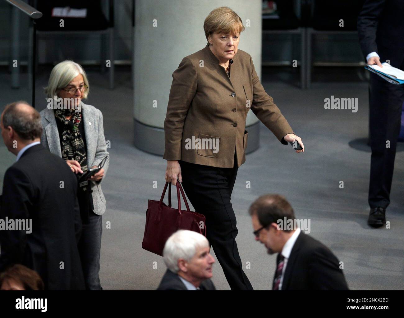 German Chancellor Angela Merkel carries a bag as she arrives for a ...
