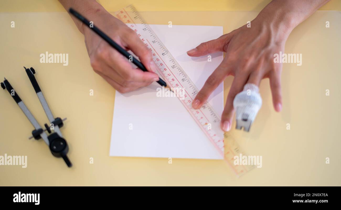 Female hand using a ruler with the pencil preparing to draw and sketch ...