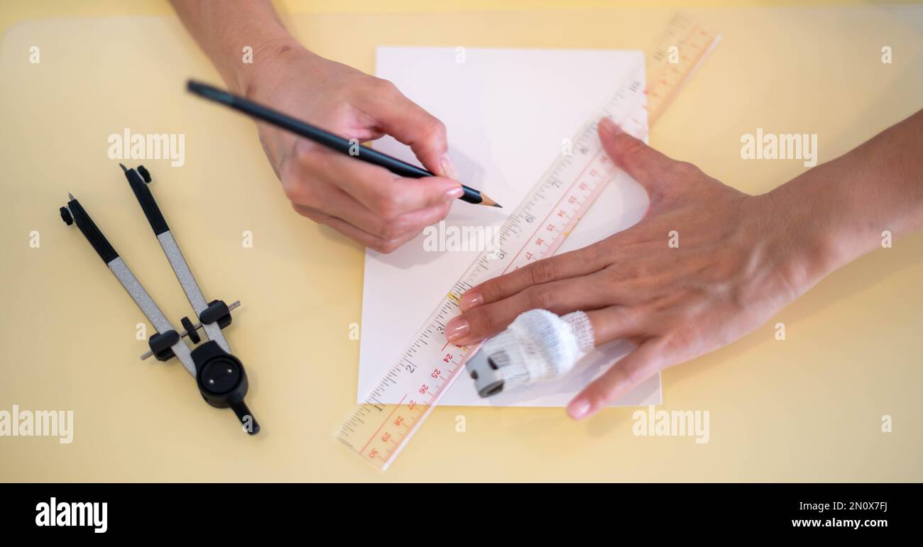 Female hand using a ruler with the pencil preparing to draw and sketch ...