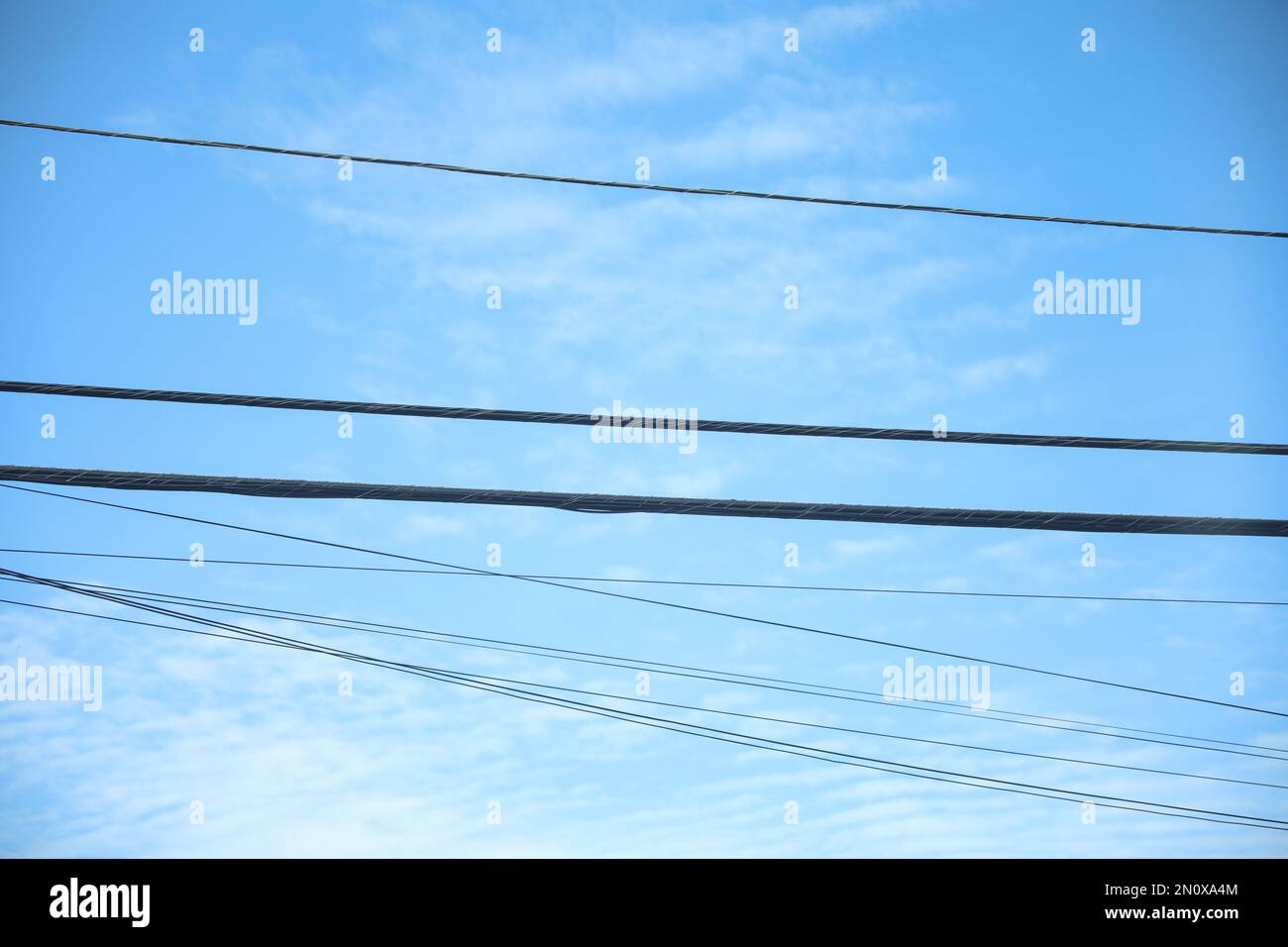 Electric power lines in the clear blue sky Stock Photo - Alamy