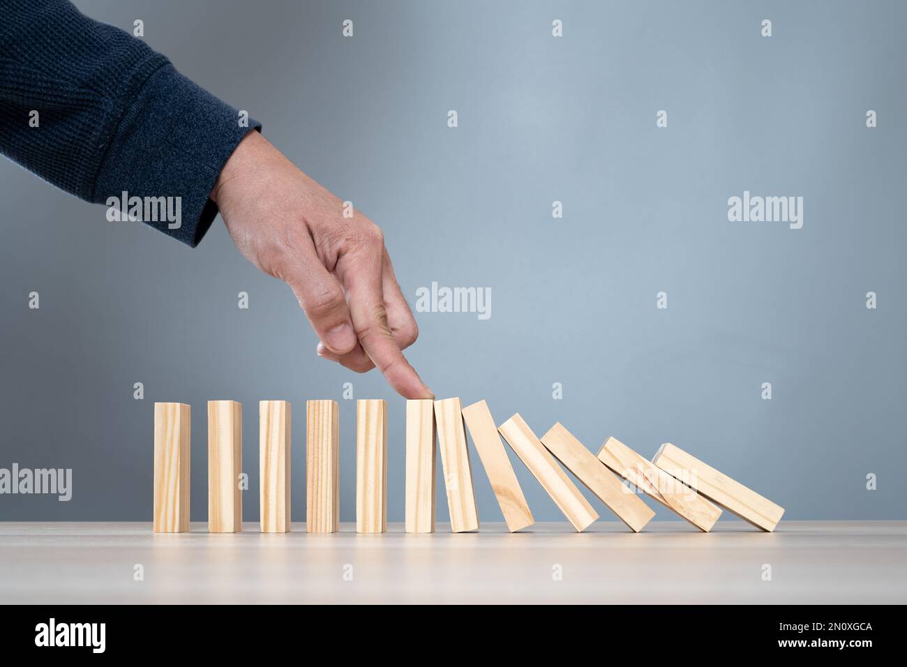 Concept of stopping domino effect Stock Photo - Alamy