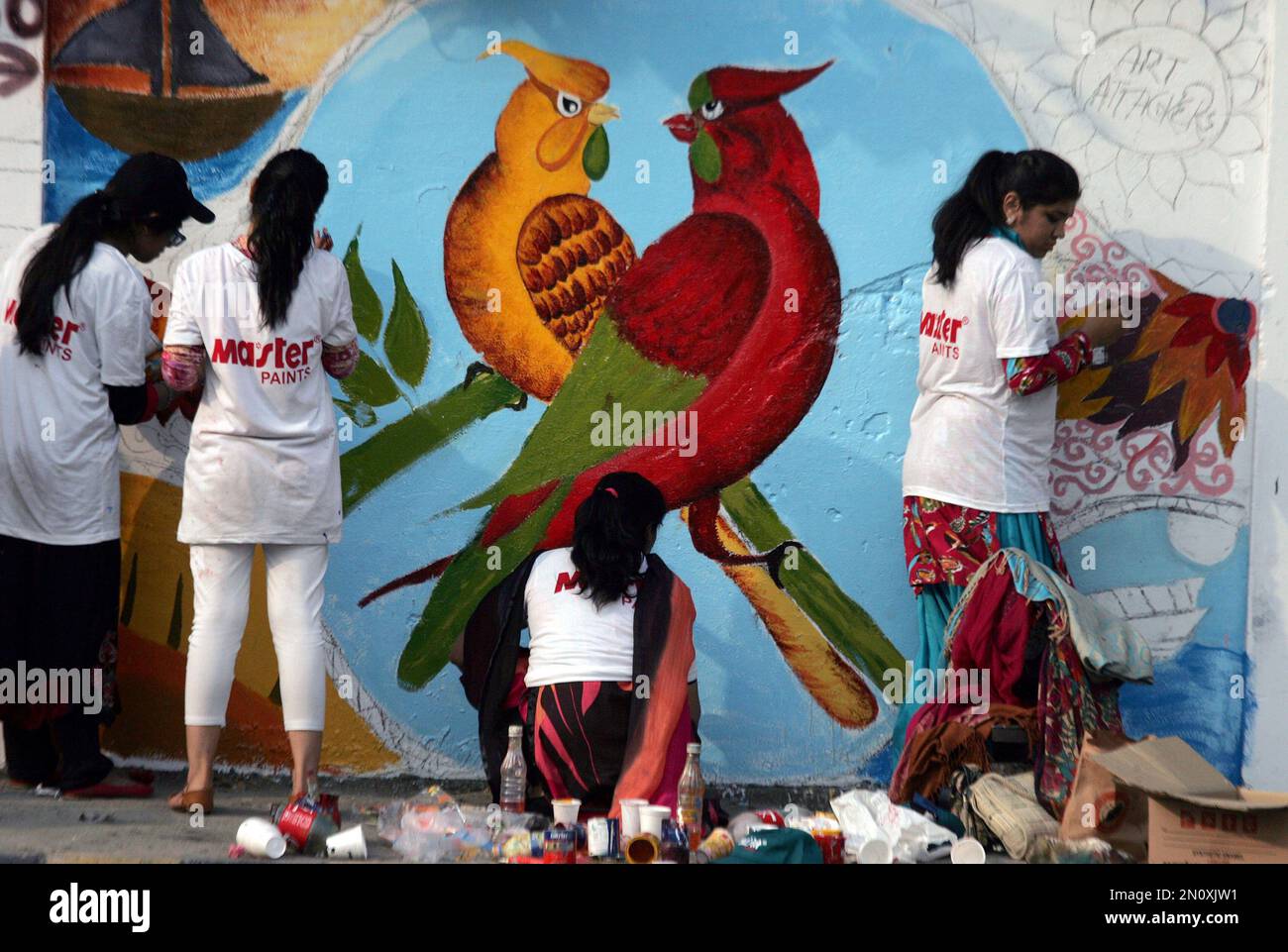 Pakistani students put the final touches to a mural on a wall during a ...