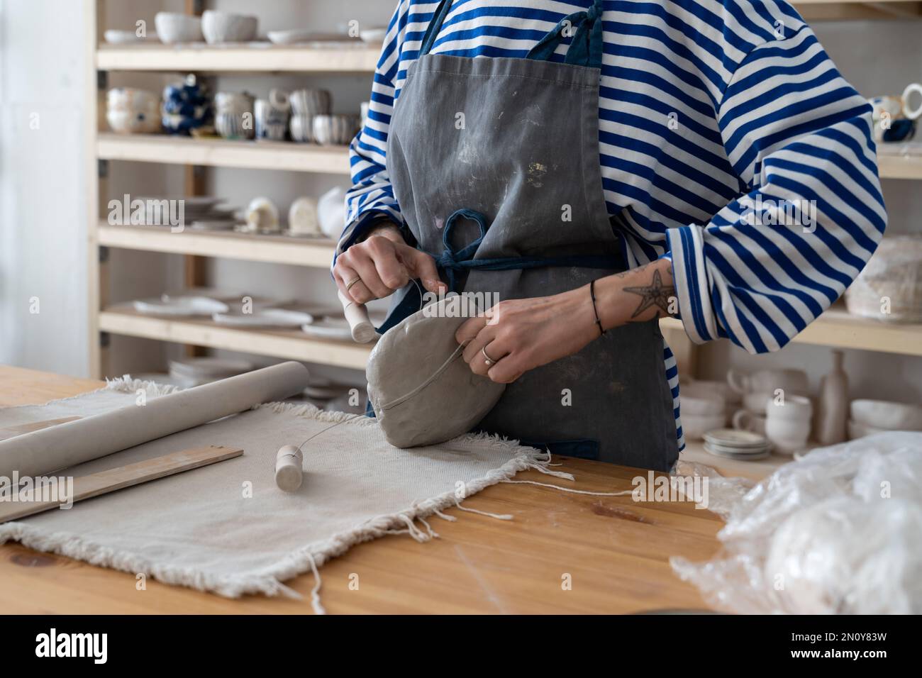 Woman cutting clay string tool hi-res stock photography and images - Alamy