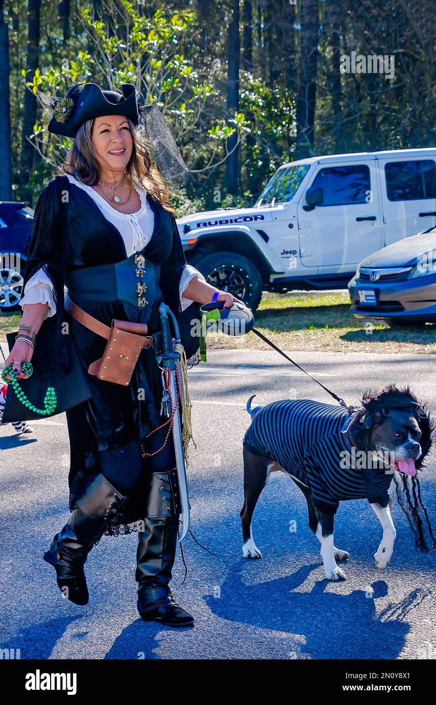 A woman walks her dog during the Mystic Krewe of Salty Paws Mardi Gras ...