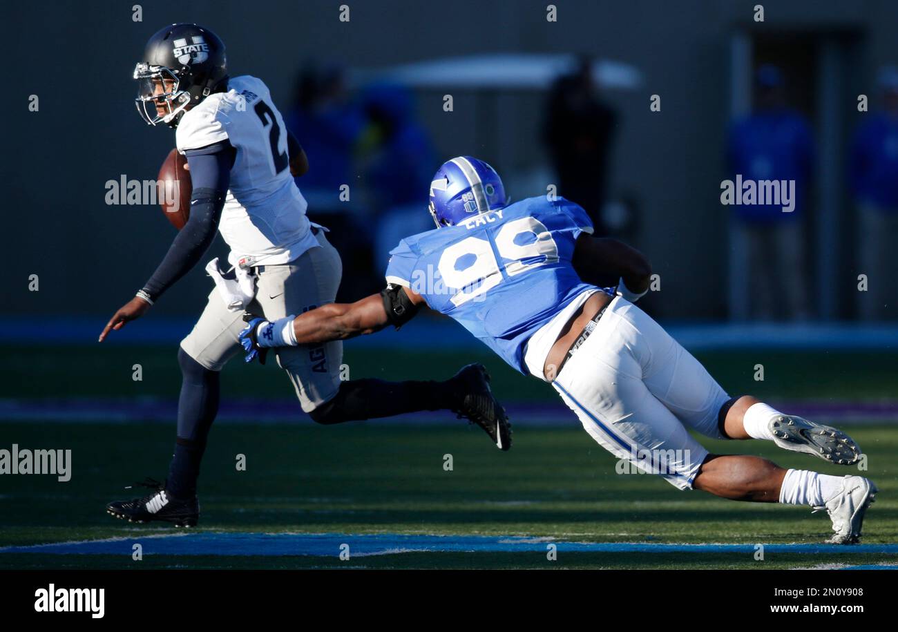 Utah State Aggies quarterback Kent Myers (2), left, eludes Air Force Falcons defensive lineman ...
